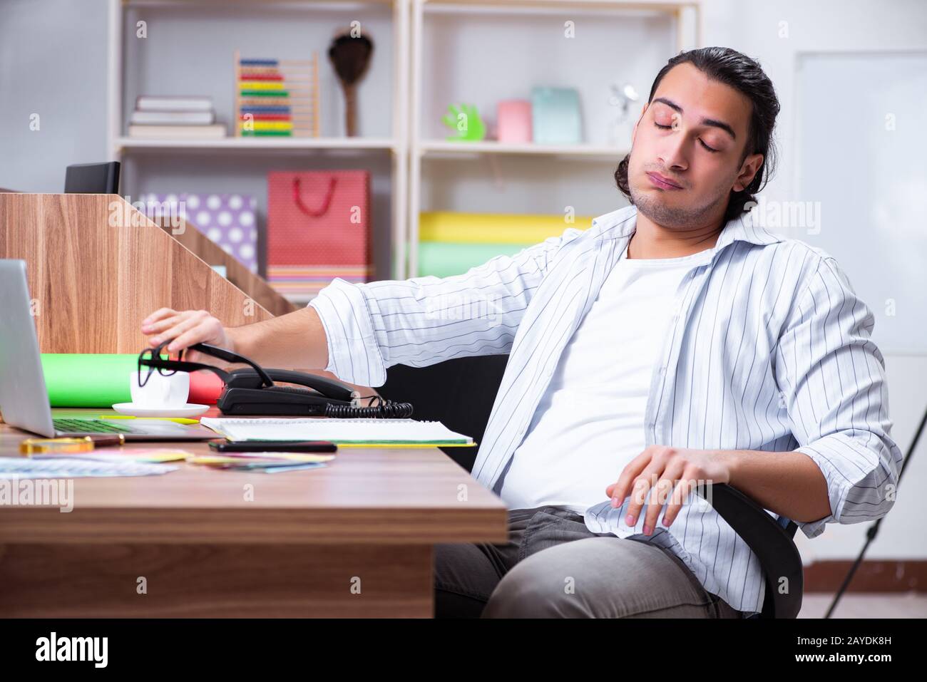 Exhausted young creative designer working hi-res stock photography and ...