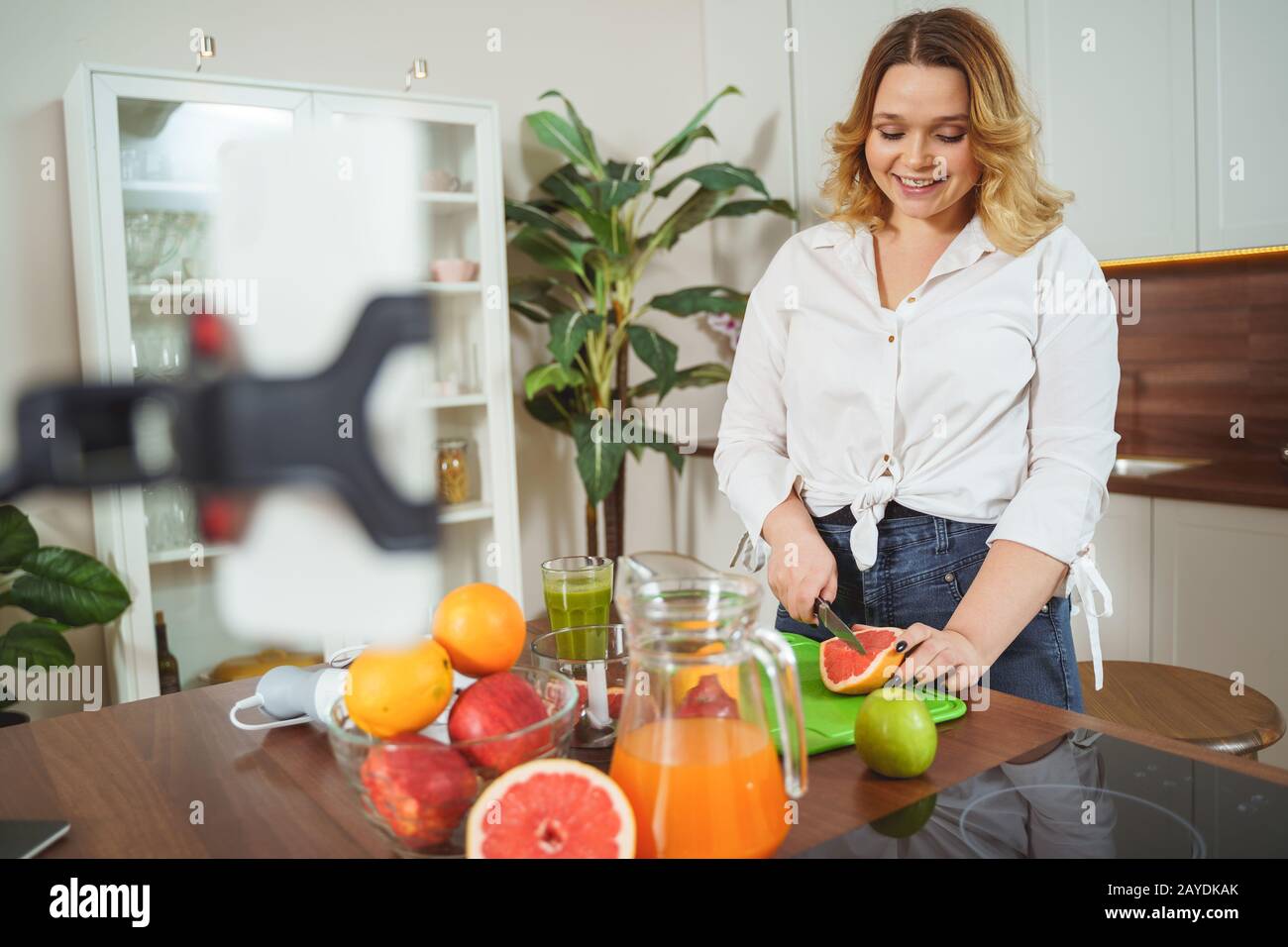 Positive delighted female shooting her cooking vlog Stock Photo - Alamy