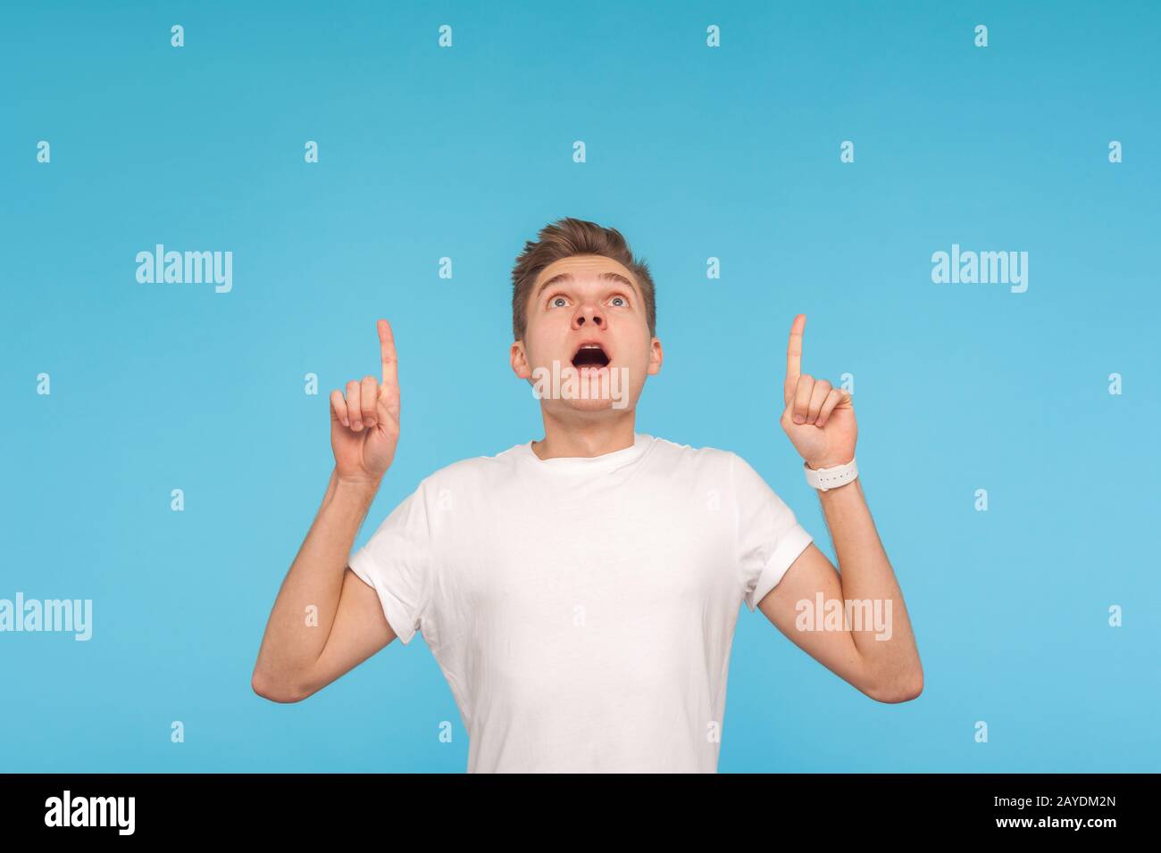 Shocking advertise here! Portrait of young man looking amazed and ...