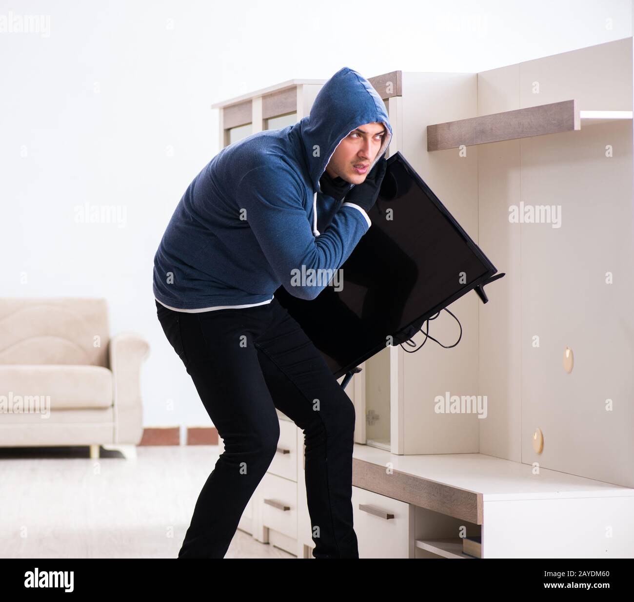 Man burglar stealing tv set from house Stock Photo - Alamy
