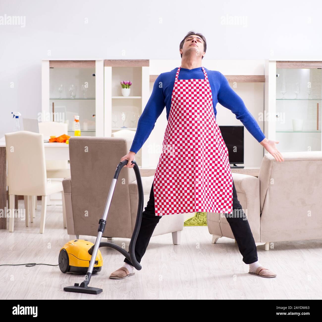 Young man vacuum cleaning his apartment Stock Photo - Alamy