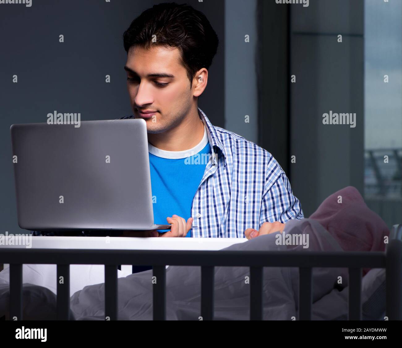 Young student doing homework and looking after newborn baby Stock Photo ...