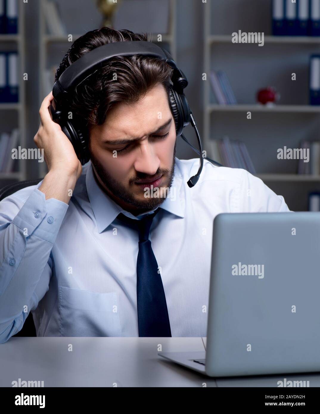 Young man in call center concept working late overtime in office Stock ...