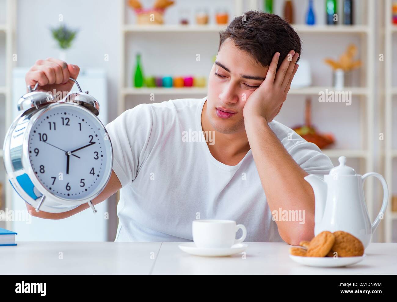 Man with alarm clock falling asleep at breakfast hi-res stock ...