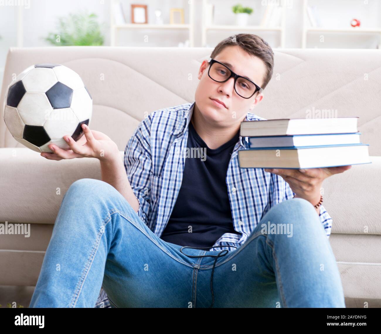 Young student trying to balance studying and playing football Stock ...