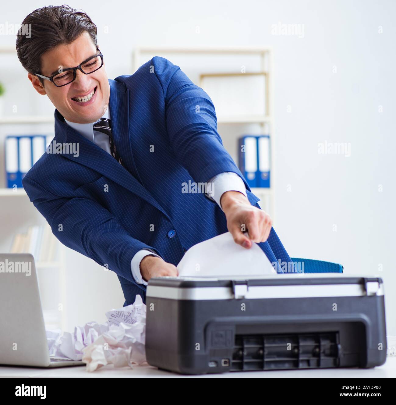 Businessman angry at copying machine jamming papers Stock Photo - Alamy