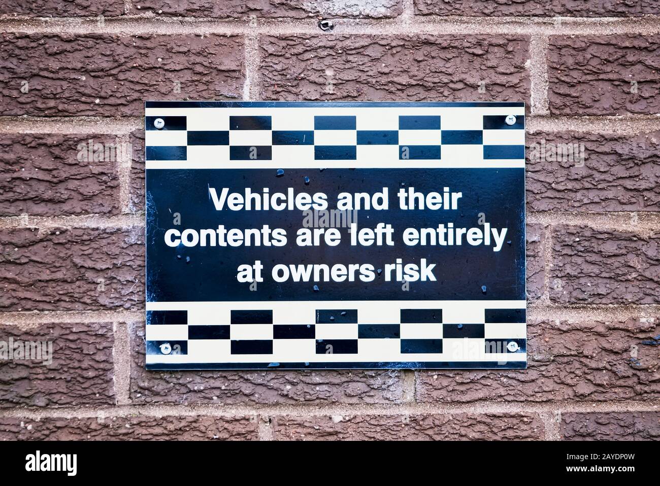 Vehicles and contents left at owners risk sign at car park Stock Photo ...