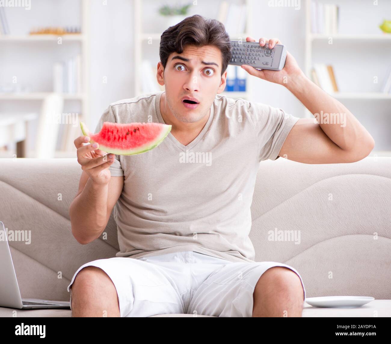 Man eating watermelon at home Stock Photo - Alamy