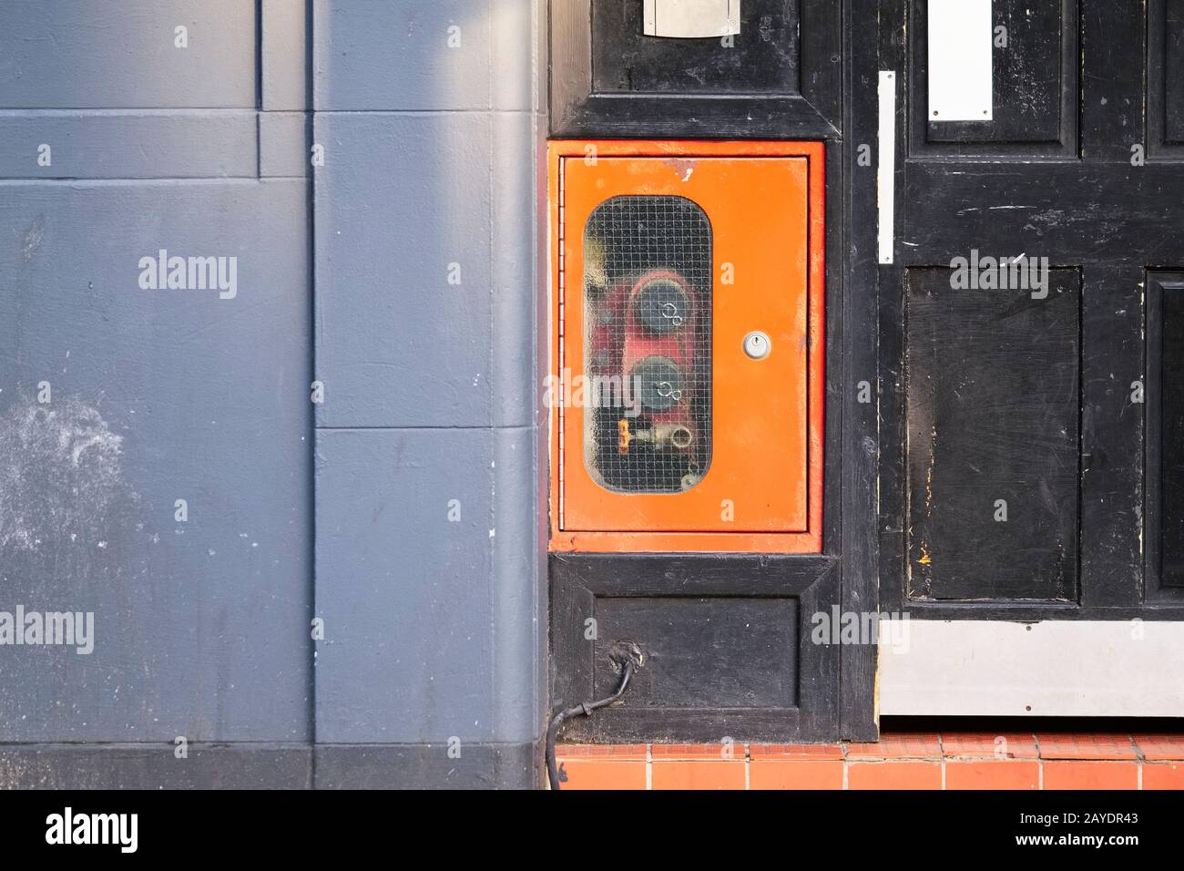 Dry riser inlet box red on brick wall for emergency fire services water ...
