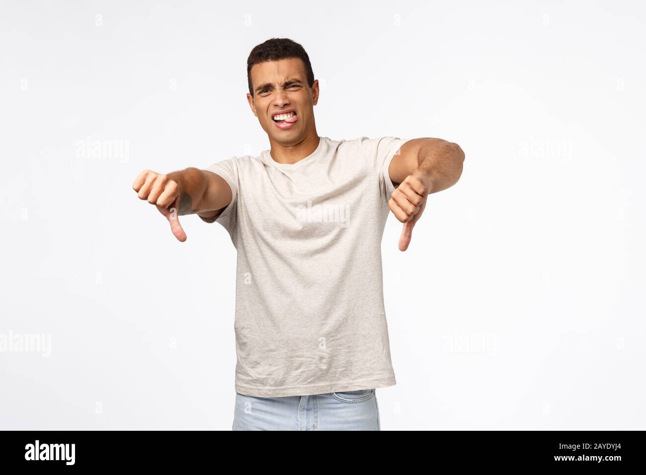 Guy express big dislike, showing thumbs down and stick tongue from ...