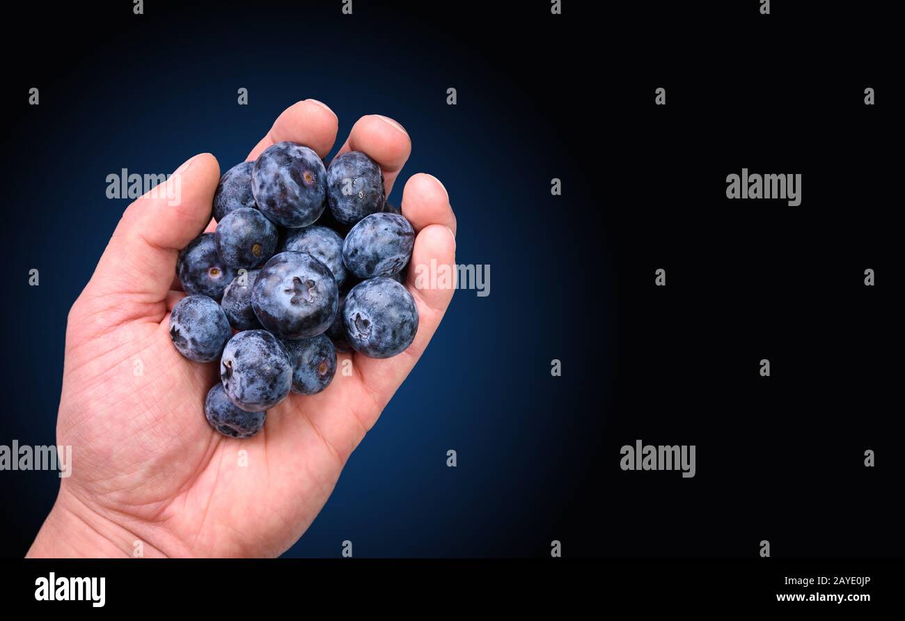 Handful of blueberries on black background. Copy space antioxidant ...