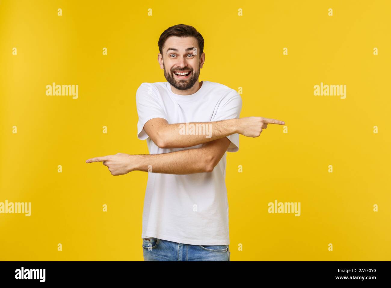 Man pointing showing copy space isolated on yellow background. Casual ...