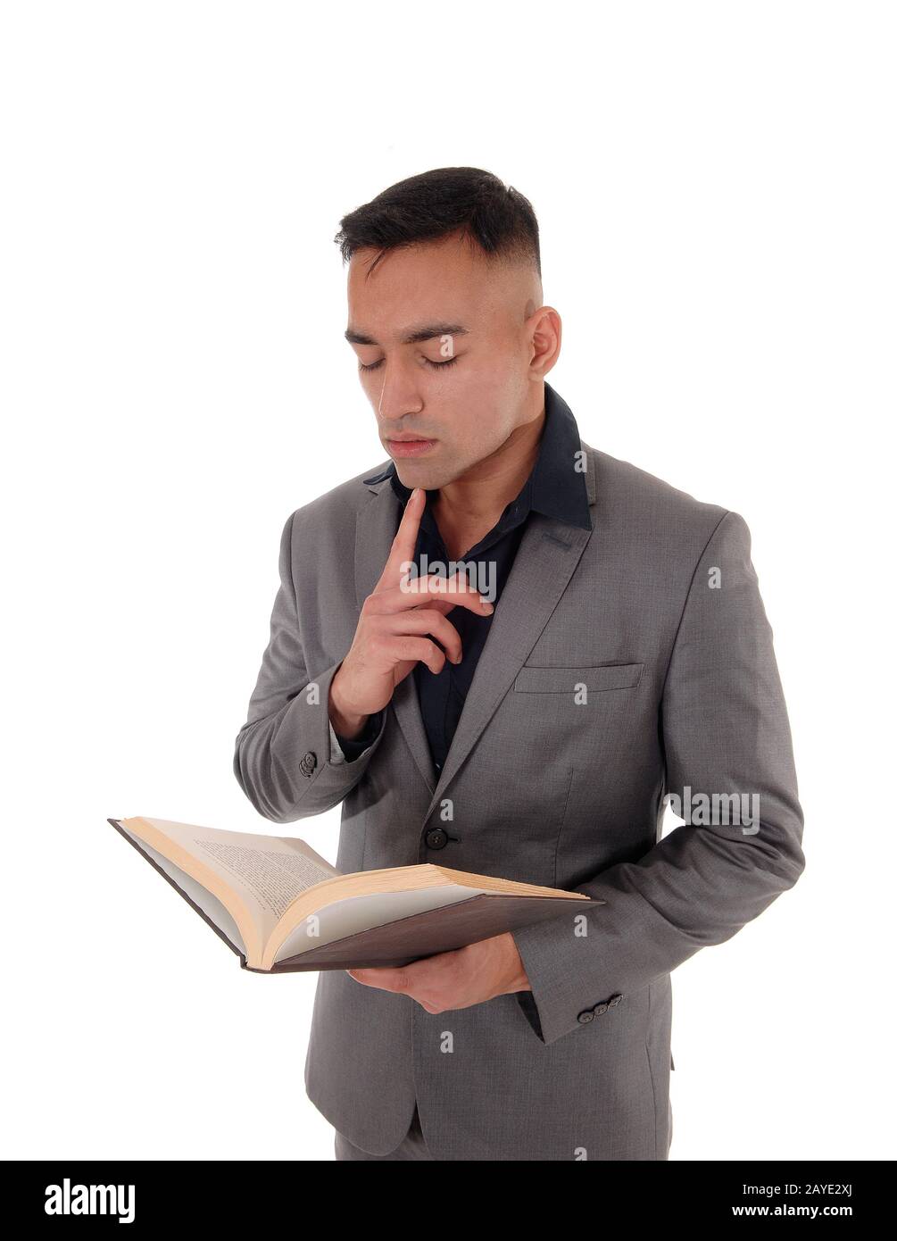 Young man standing reading his book Stock Photo - Alamy