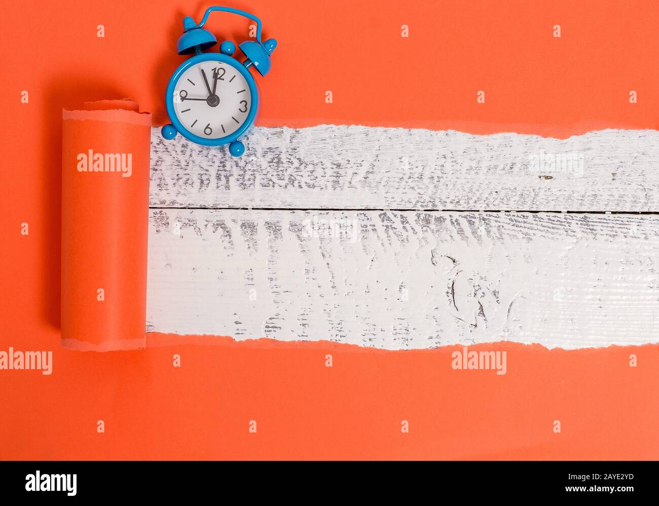 Ripped cardboard with a mini alarm clock placed above a wooden classic ...