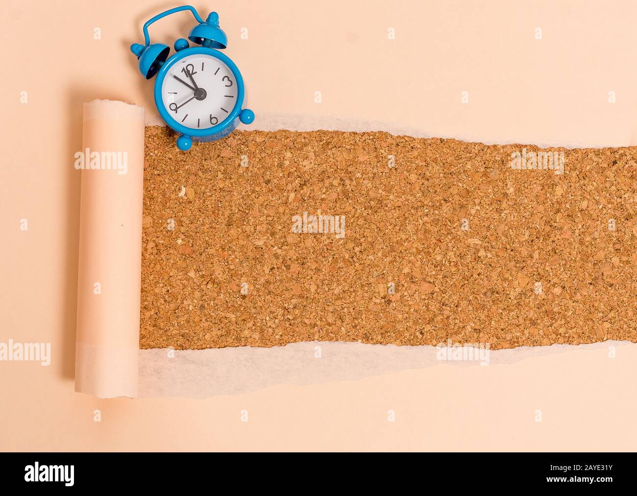 Ripped cardboard with a mini alarm clock placed above a wooden classic ...