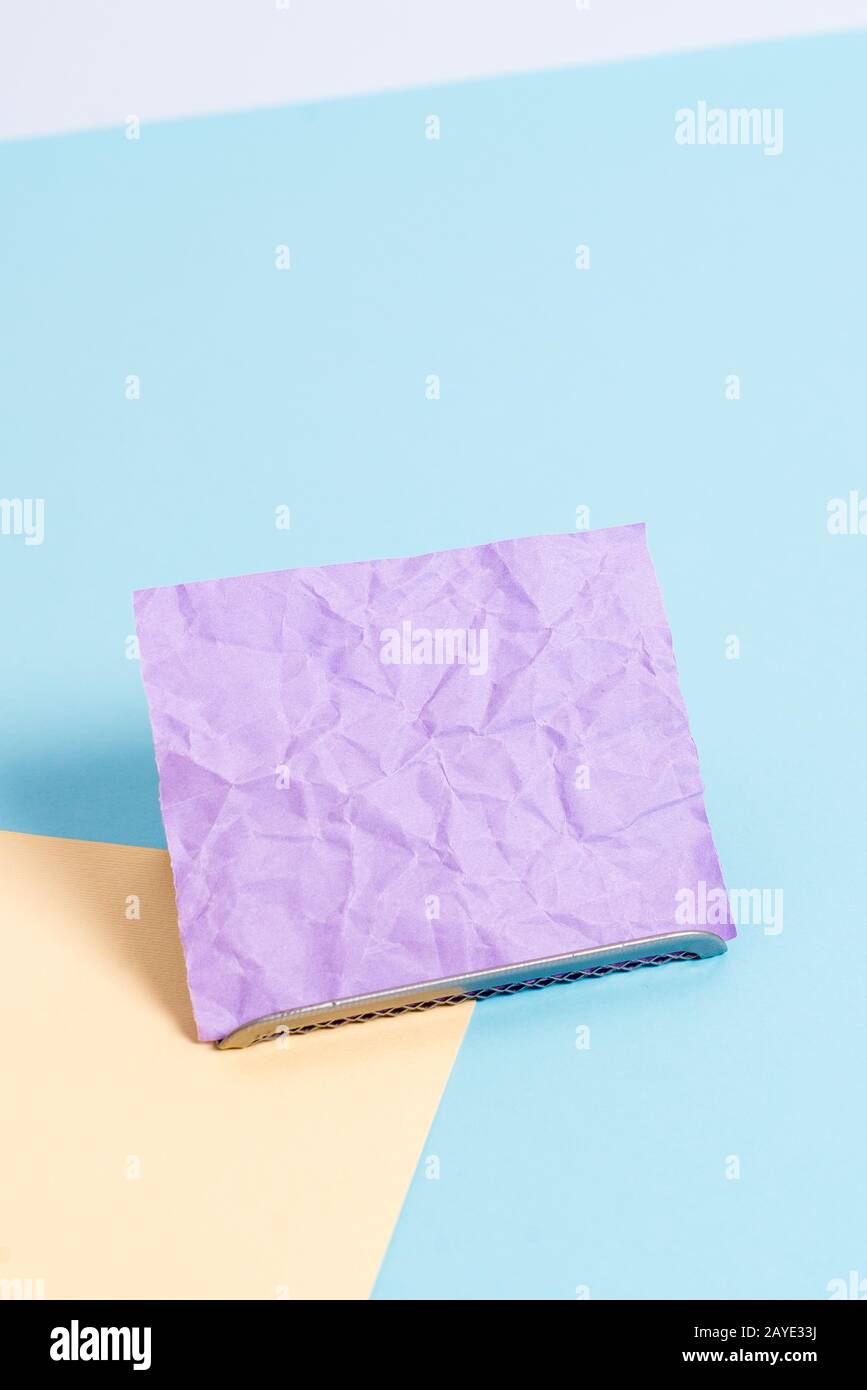 Paper sheet placed tilted on a buffer wire with a soft pastel backdrop ...