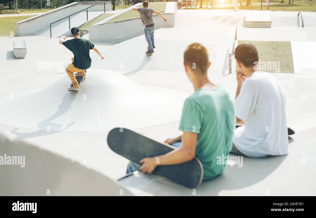 Skaters performing with skateboard in city park - Young guys performing ...