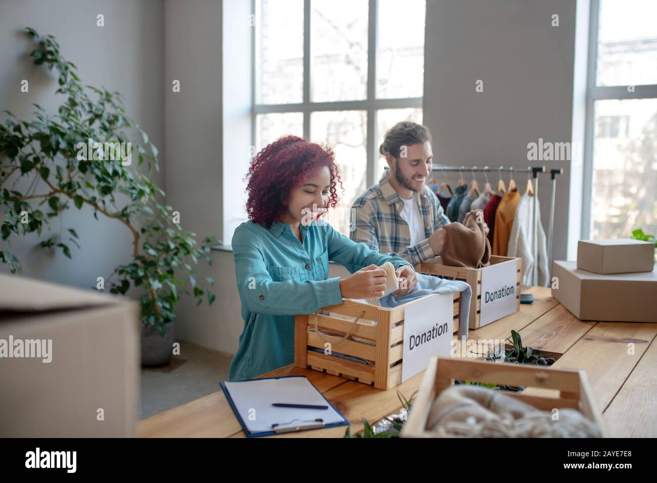Young adult man and girl sorting clothes Stock Photo - Alamy