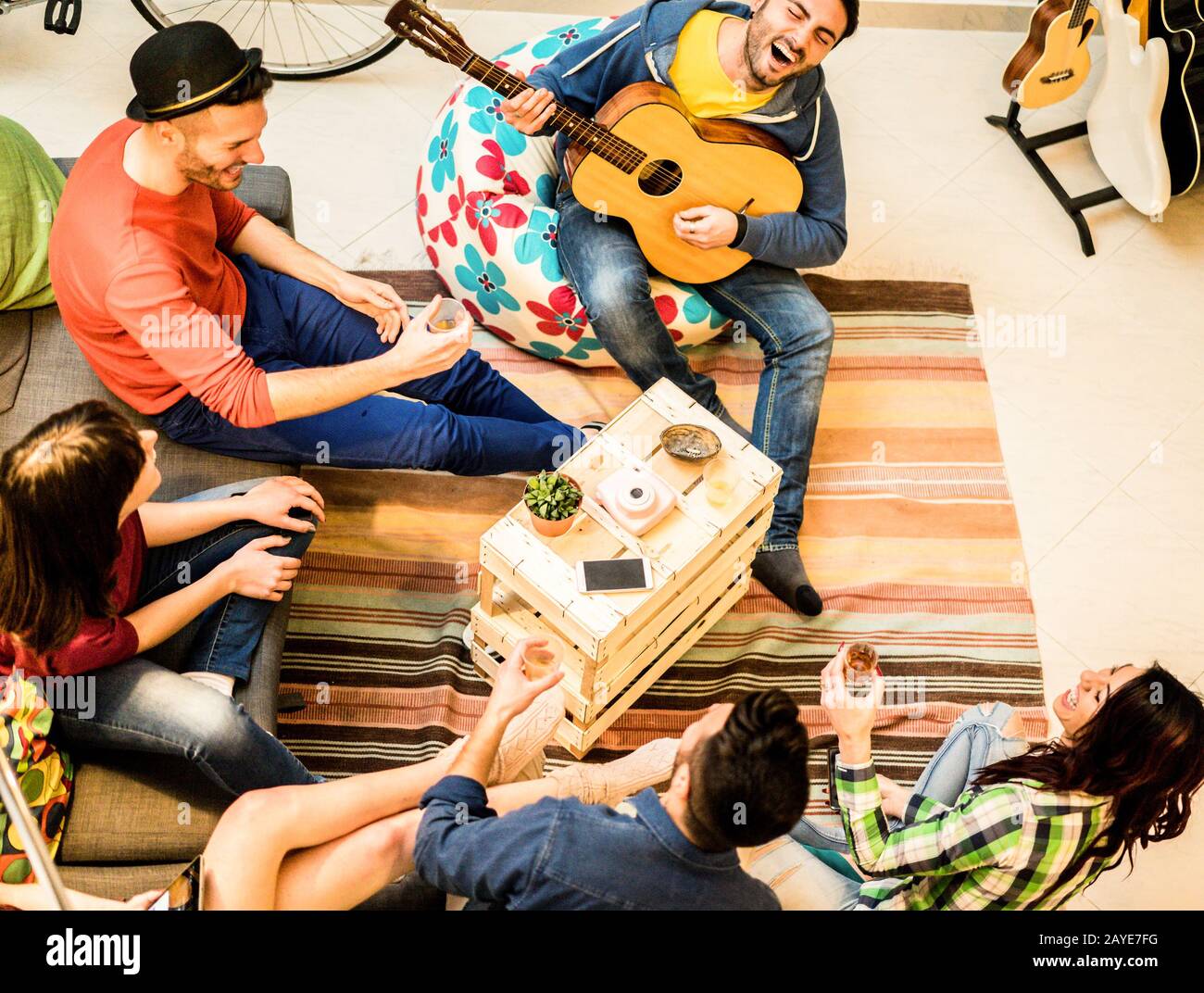 Group of trendy friends having fun in hostel living room - Happy young ...