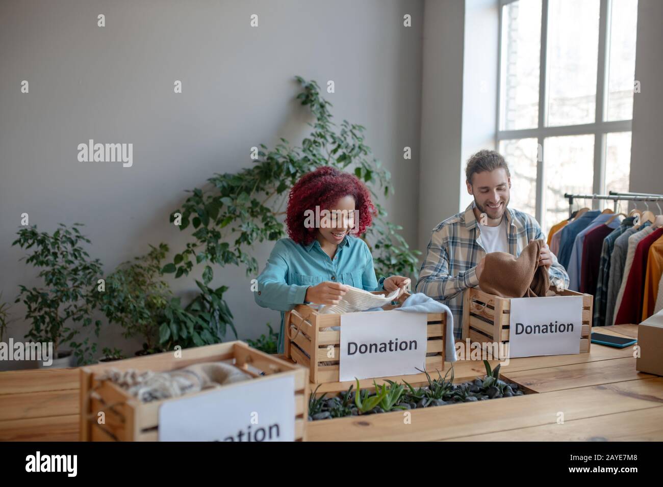 Smiling young people sorting clothes in drawers Stock Photo - Alamy