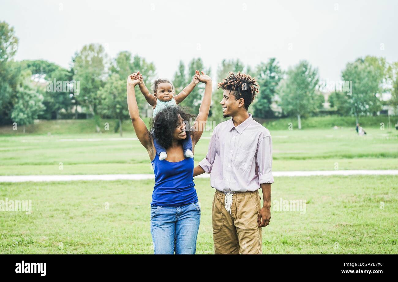 Happy african family having fun outdoor during sunny day in public park ...