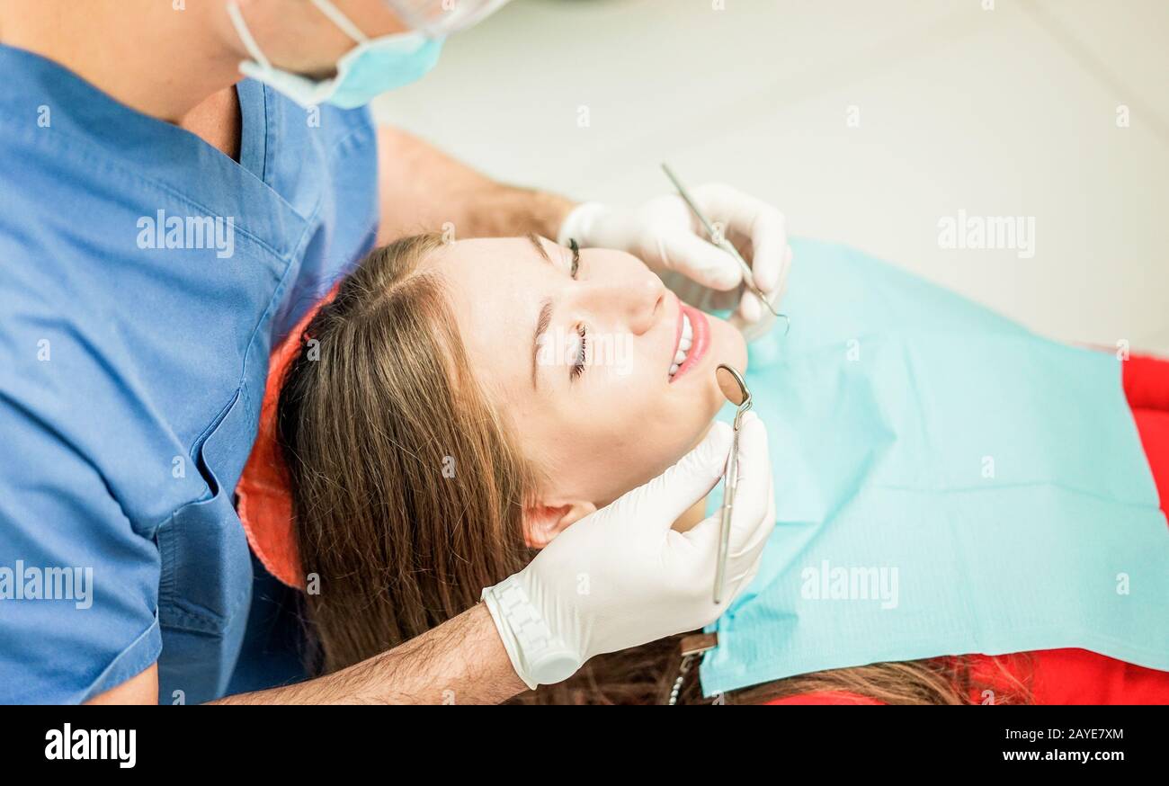 Young woman checking their teeth at mirror after dental treatment ...