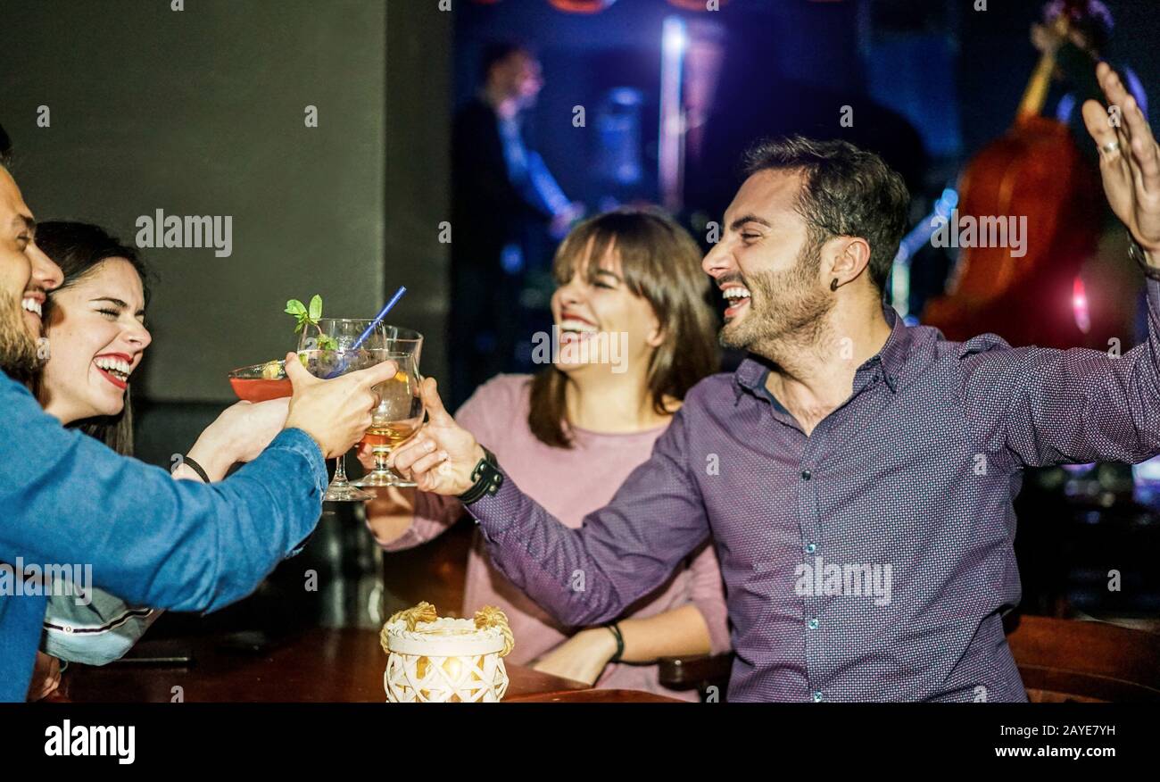 Group of happy friends cheering and having fun in jazz club - Young ...