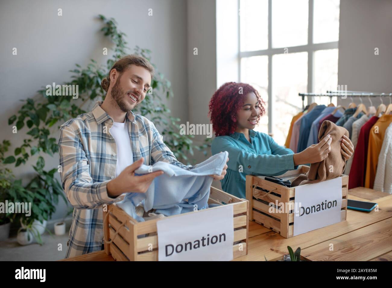 Young man and girl looking at clothes from drawers Stock Photo - Alamy