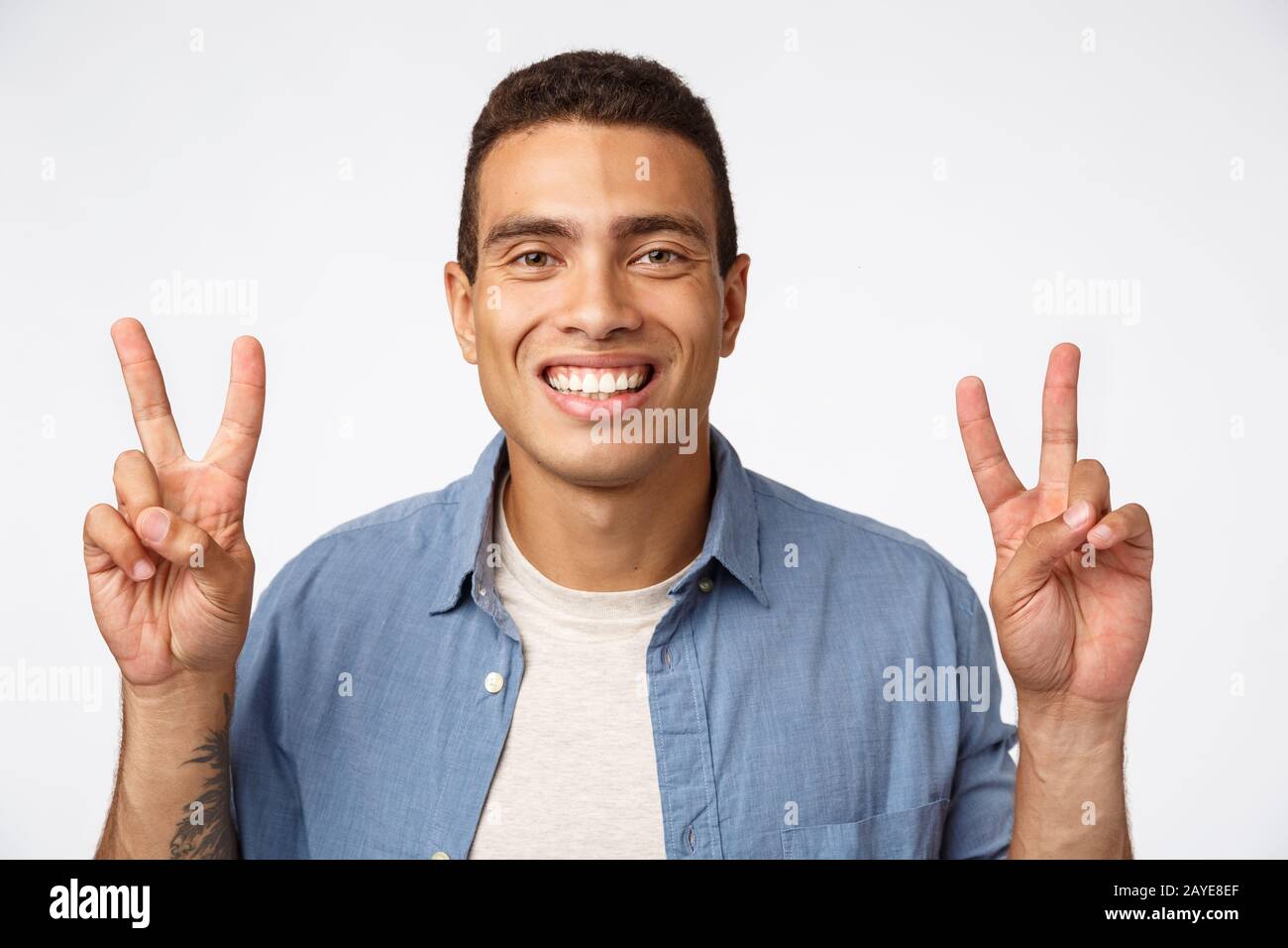 Cheerful young athletic man in casual outfit smiling happily, showing ...