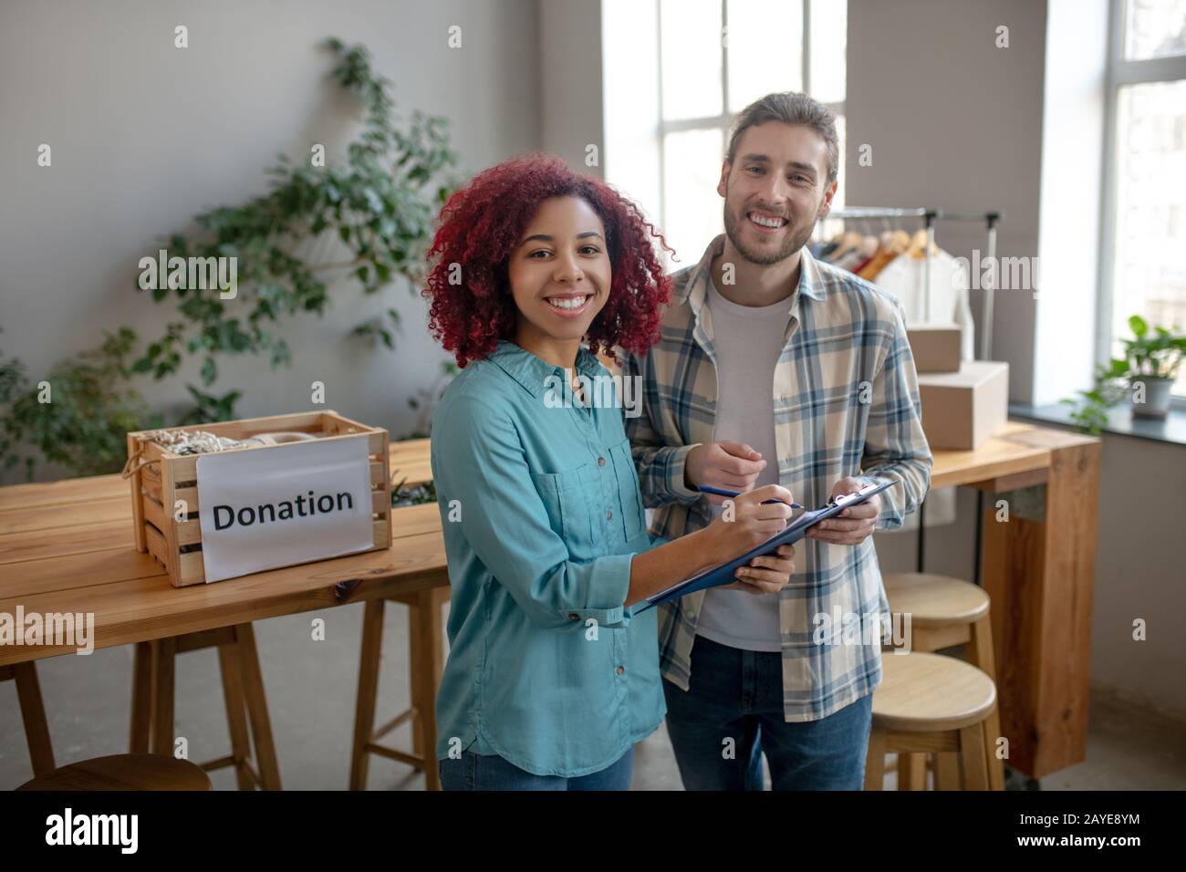 Young girl and man standing writing in notebook Stock Photo - Alamy