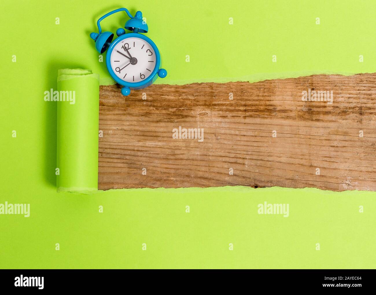 Ripped cardboard with a mini alarm clock placed above a wooden classic ...