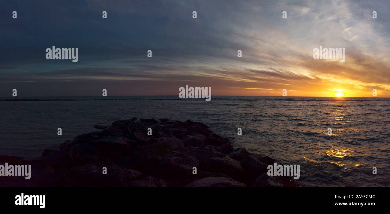 Amazing sunset seascape panoramic from rocky breakwater, sun up the ...