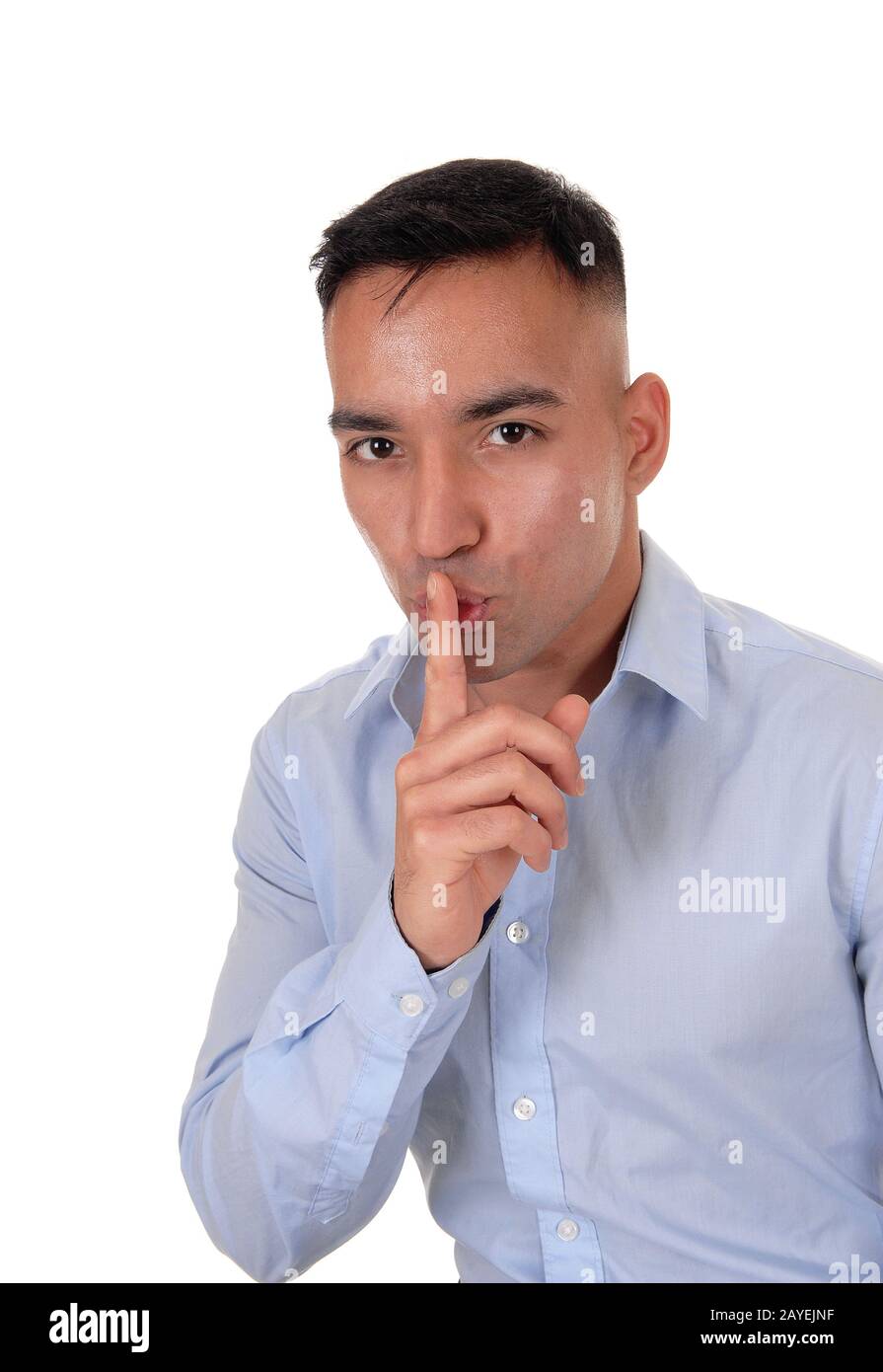 Young man with his finger over his mouth Stock Photo - Alamy