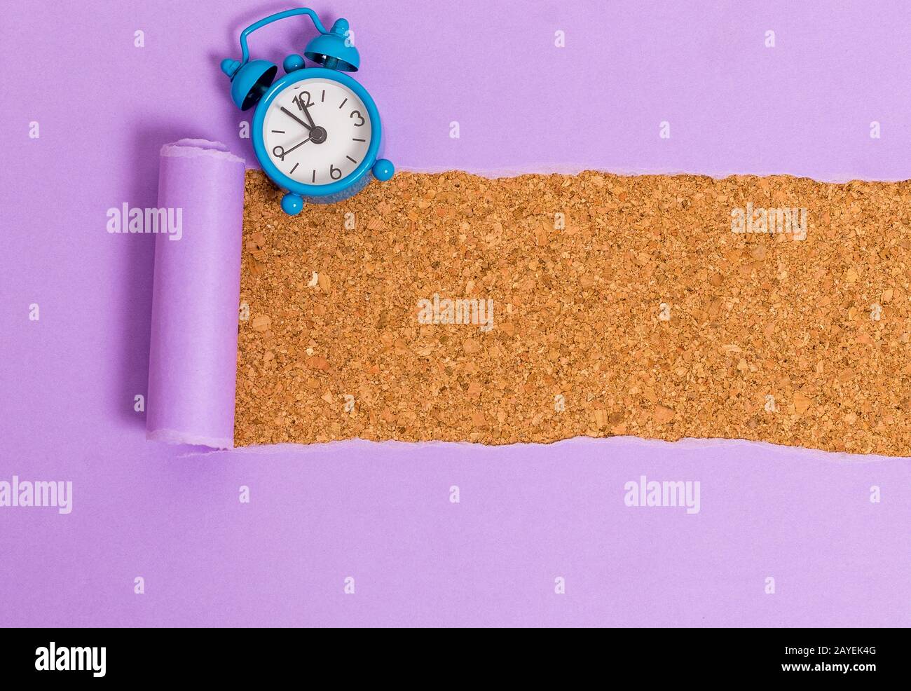 Ripped cardboard with a mini alarm clock placed above a wooden classic ...