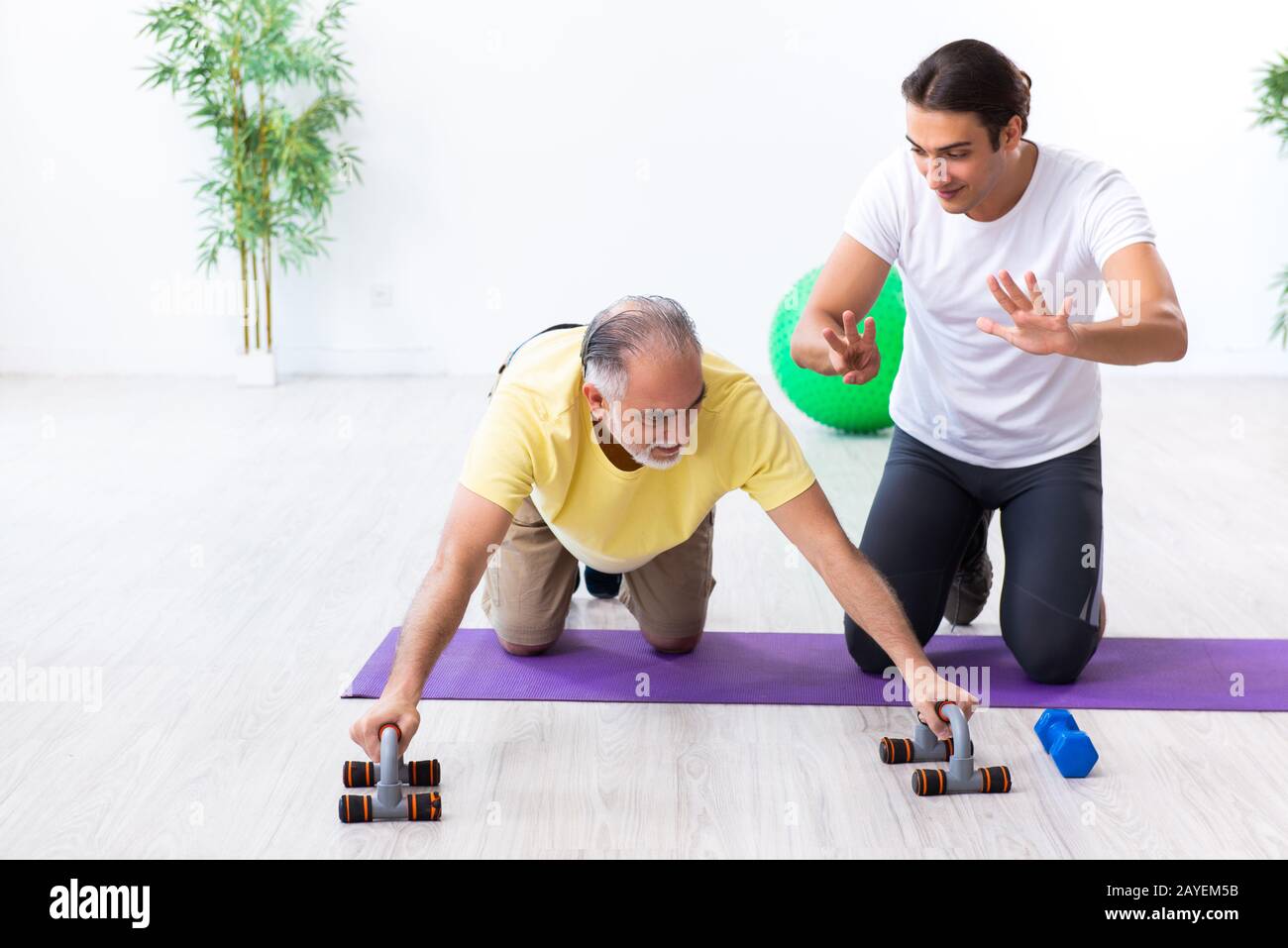 Old man doing exercises indoors Stock Photo - Alamy