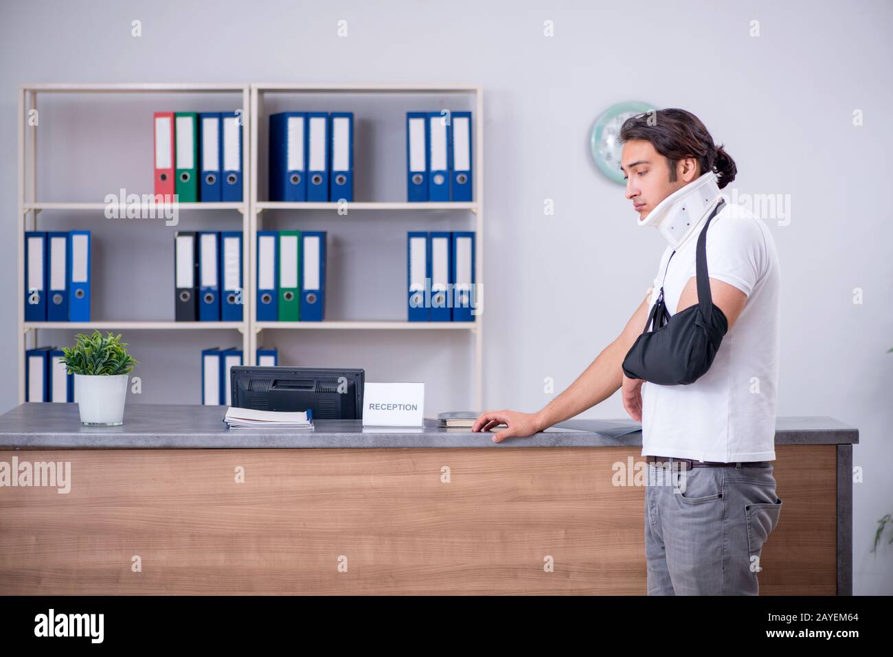 Young man at hospital reception desk Stock Photo - Alamy