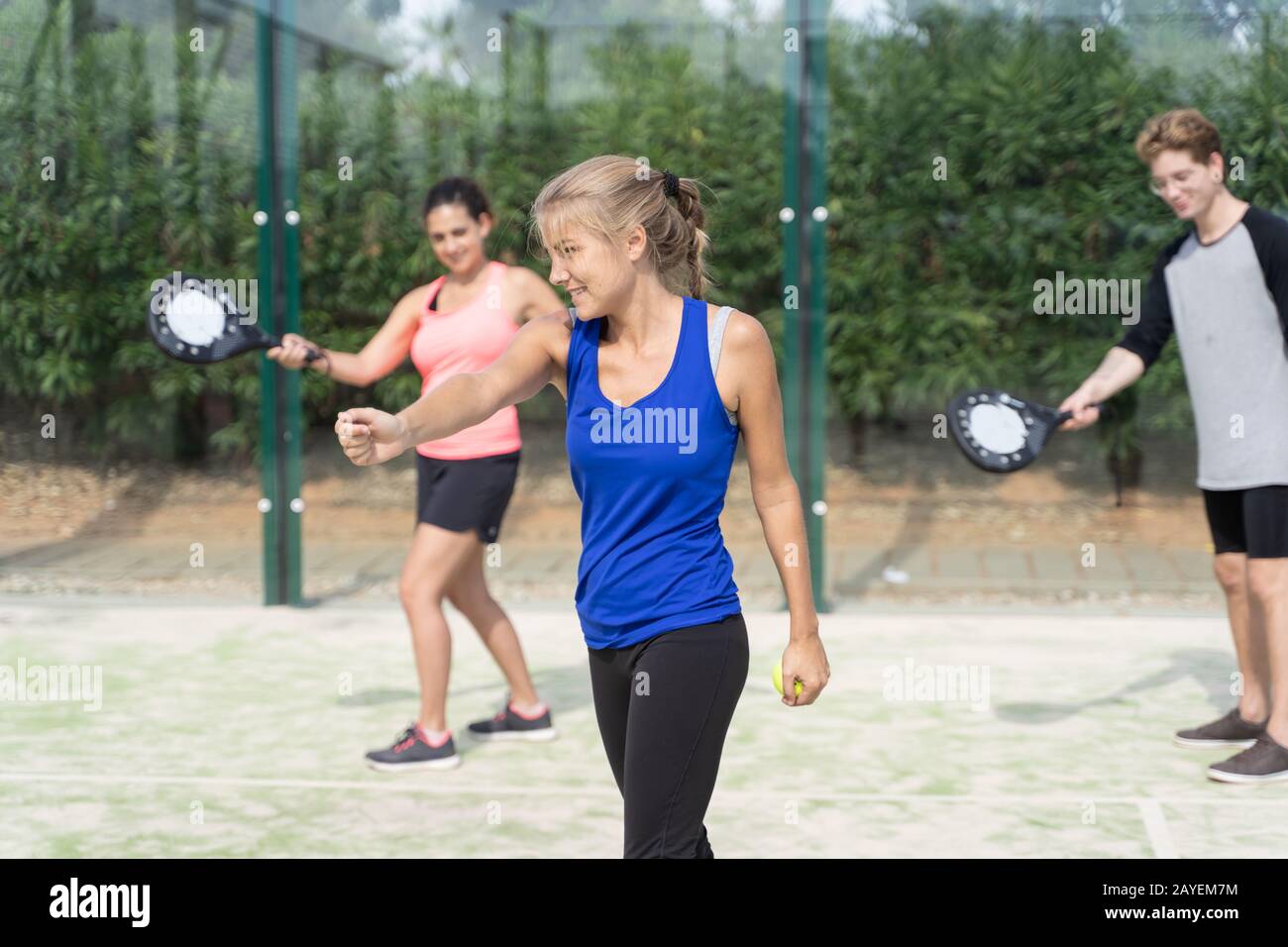 Blonde girl teaching correct paddle moves to a group of youngsters on ...