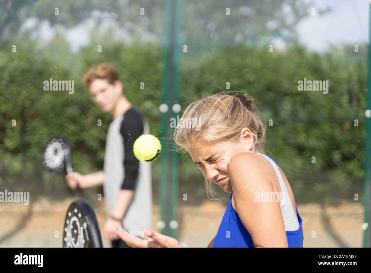 Ball hitting the forehead of a blonde girl with a paddle racket in ...