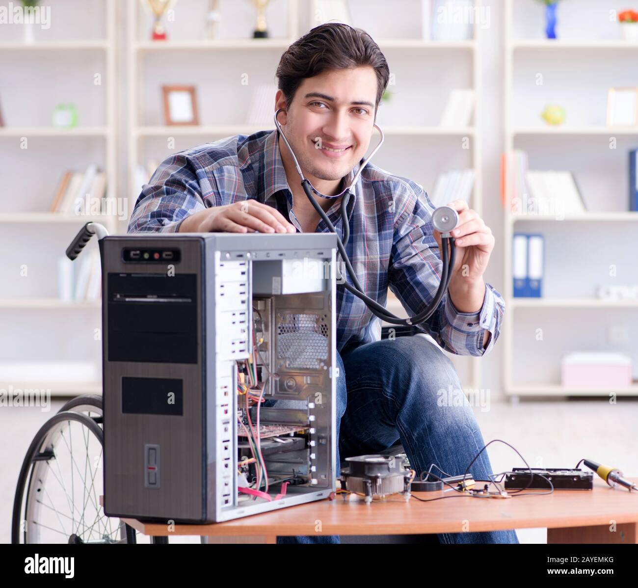 Disabled man on wheelchair repairing computer Stock Photo - Alamy