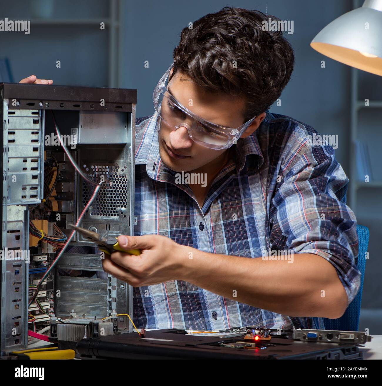 The man repairing computer desktop with pliers Stock Photo - Alamy