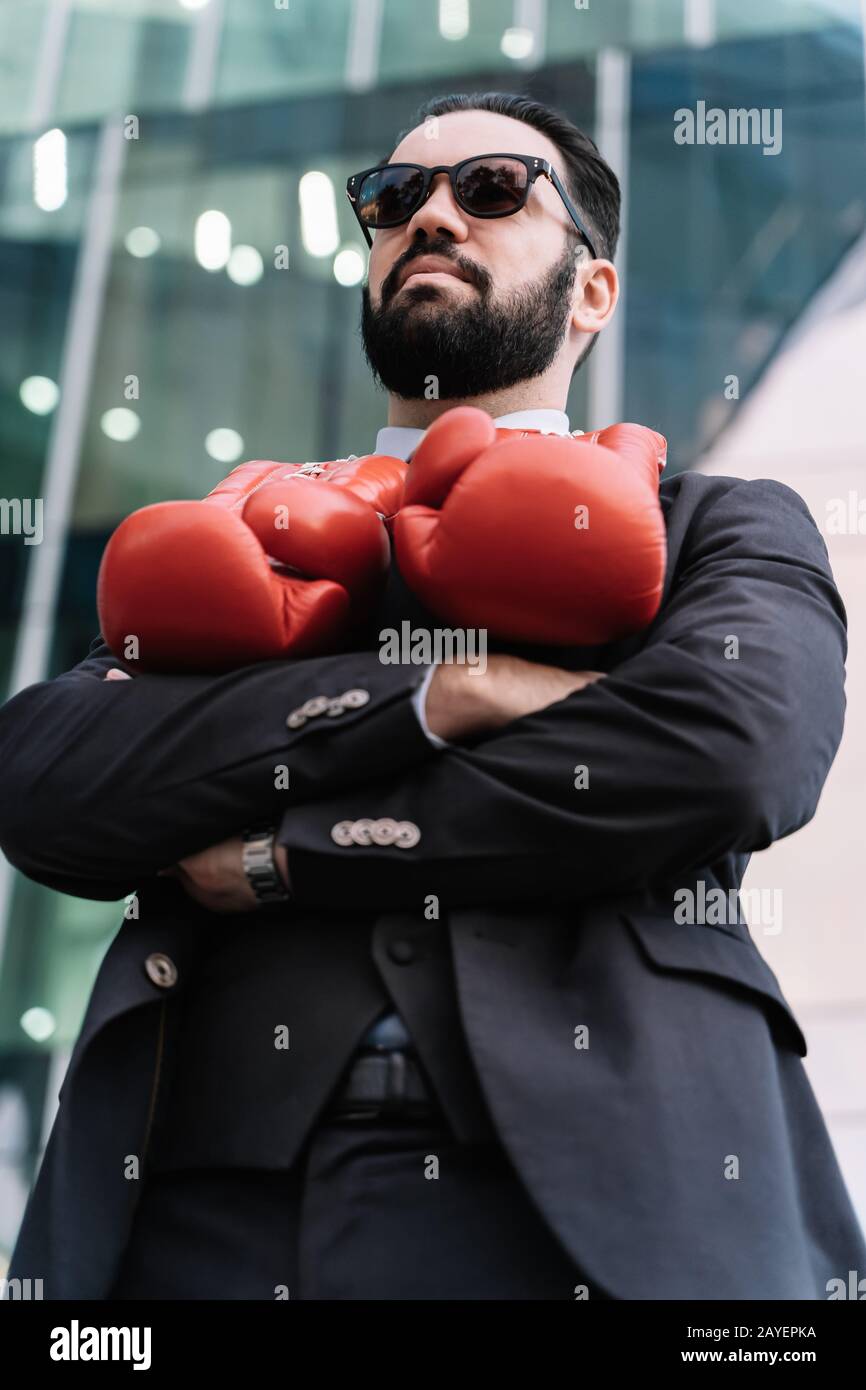 Vertical photo of a businessman with sunglasses and red boxing gloves ...