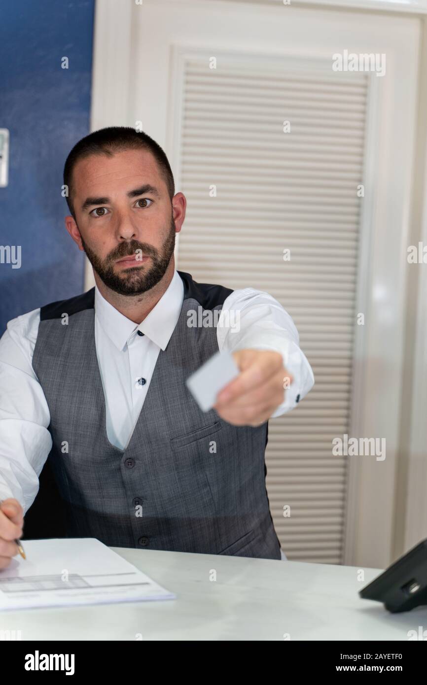Stock vertical photo of a young man in uniform working in a hotel ...