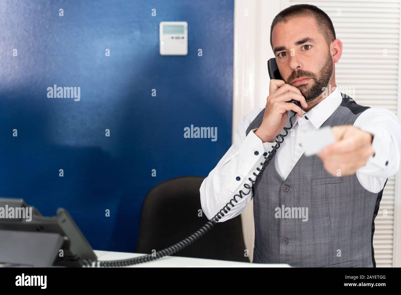 Stock photo of an uniformed hotel receptionist answering the phone ...