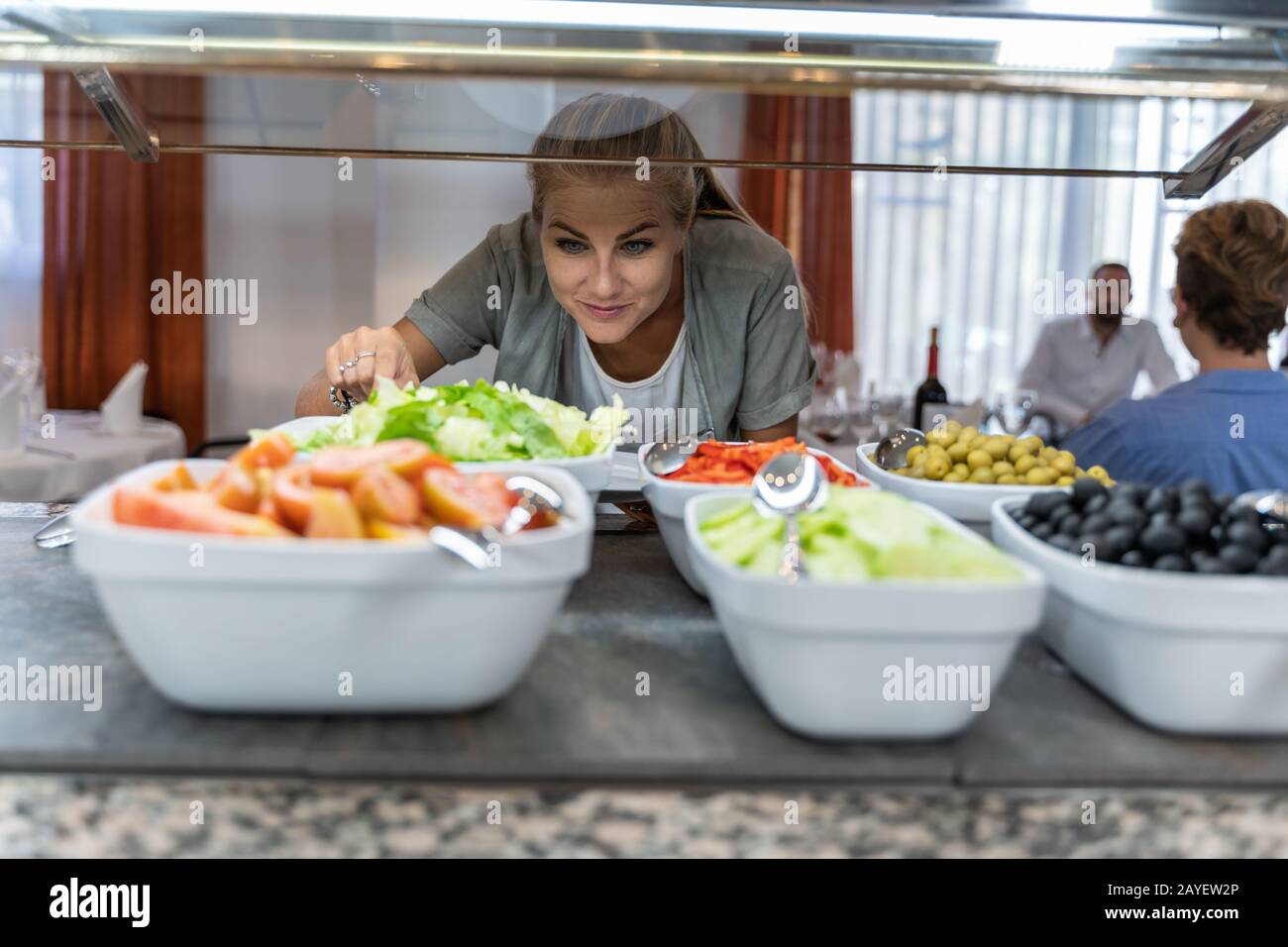 Stock photo of a blonde girl crouching for food in front of a self ...
