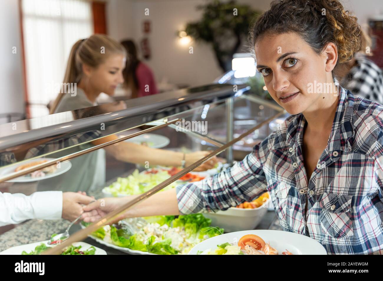 Stock photo of two girls on either side of a counter picking up food at ...