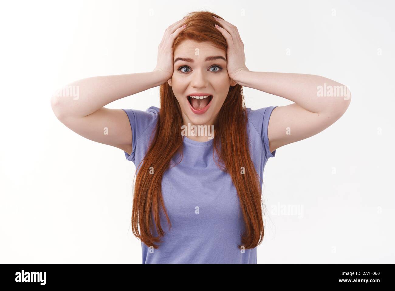 Surprised excited girl feeling overjoy and amazement, grab head and ...