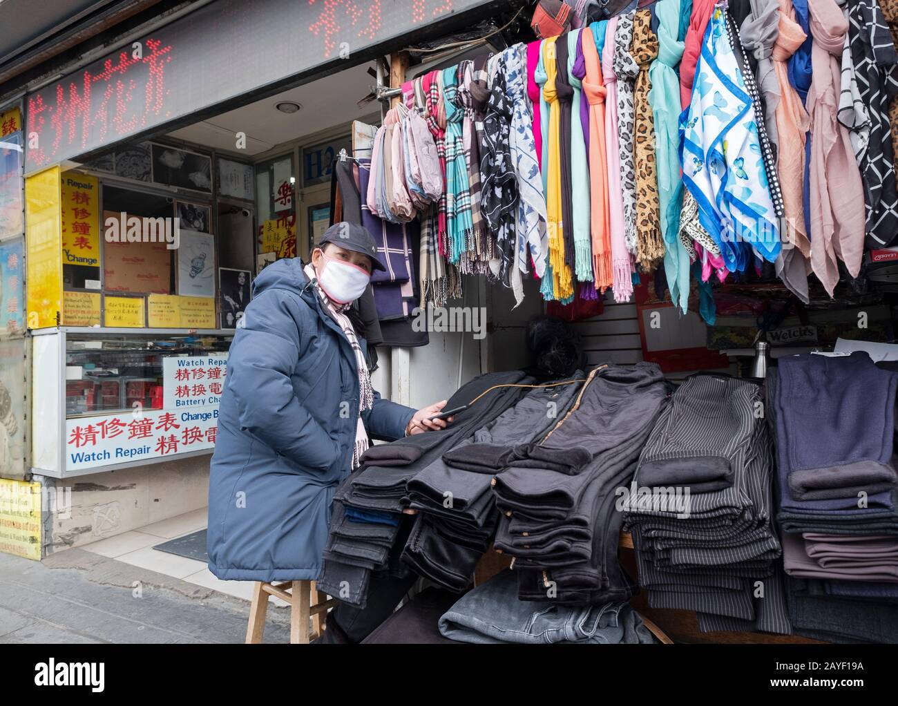 Portrait of a clothing salesman wearing a surgical mask. On Main Street ...