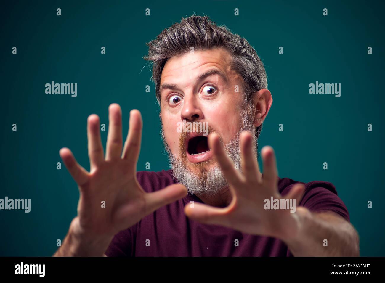A portrait of scared bearded man in red t-shirt. People and emotions ...