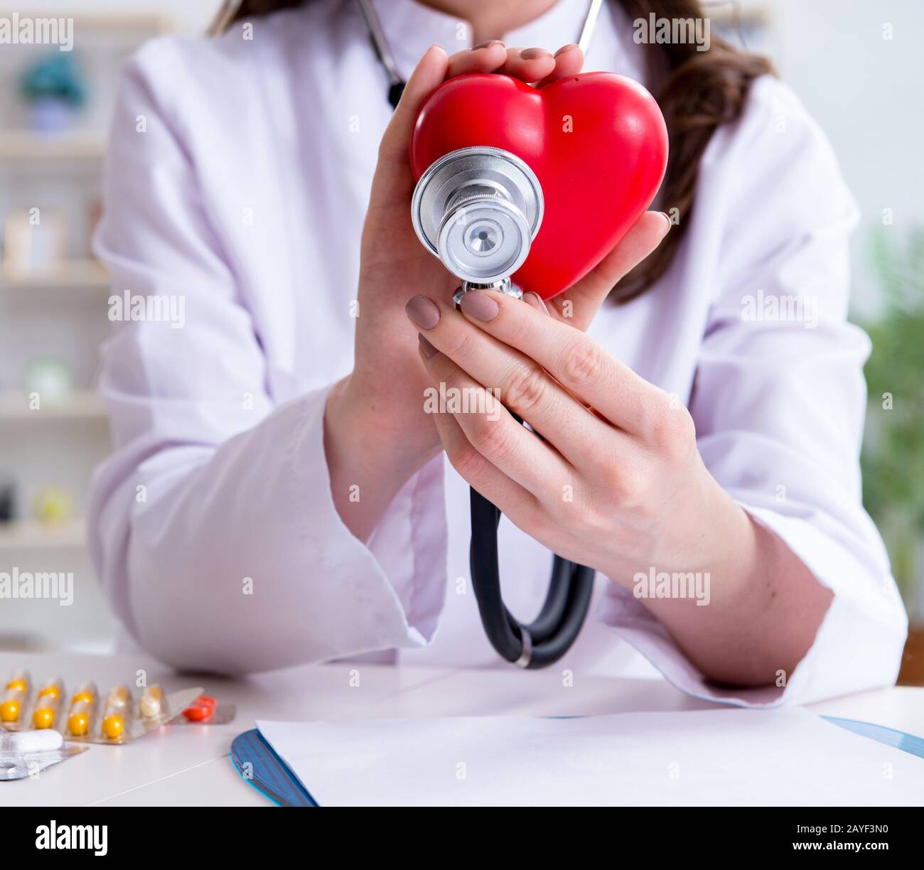 Doctor cardiologist with red heart in the hospital Stock Photo - Alamy