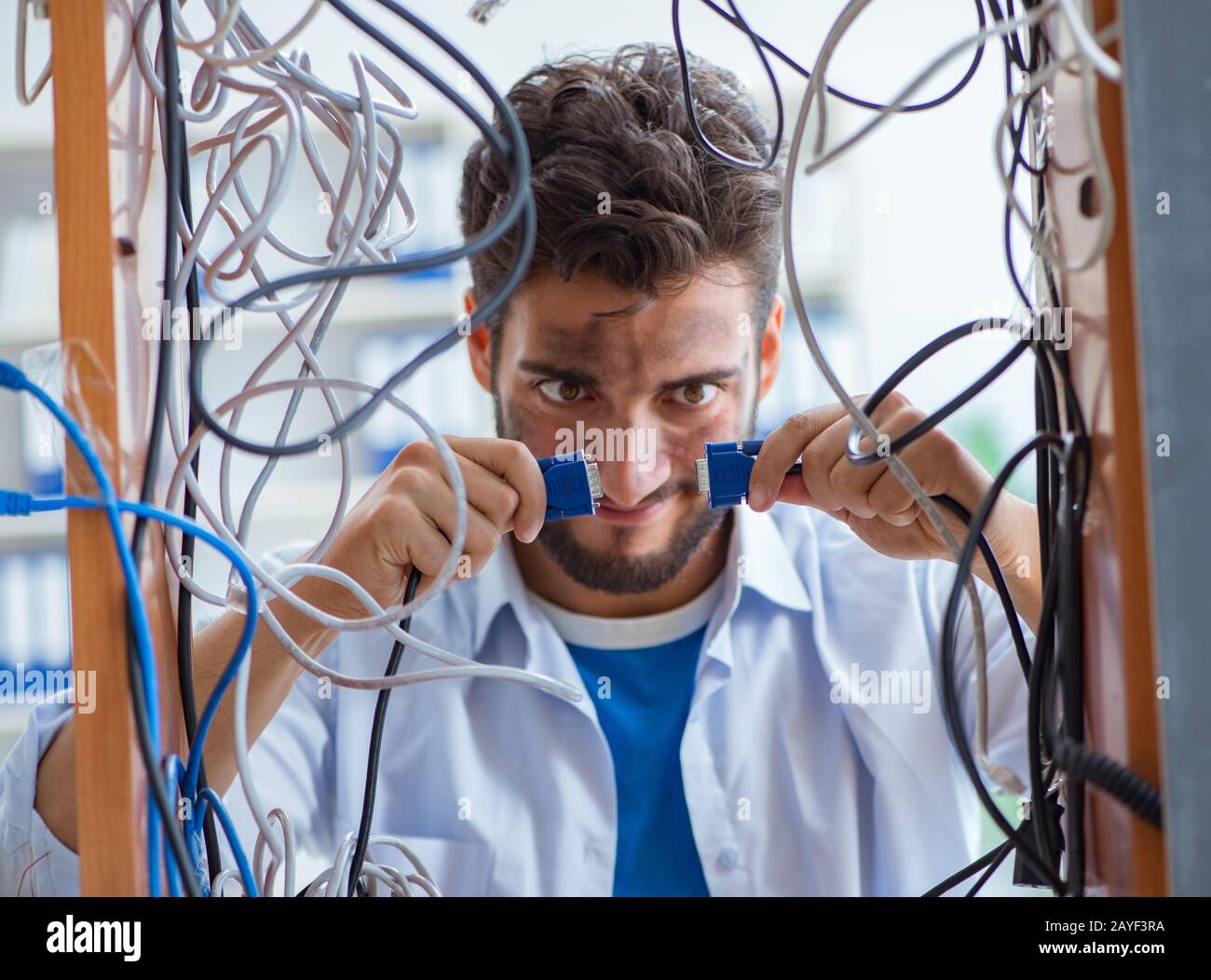 Electrician trying to untangle wires in repair concept Stock Photo - Alamy